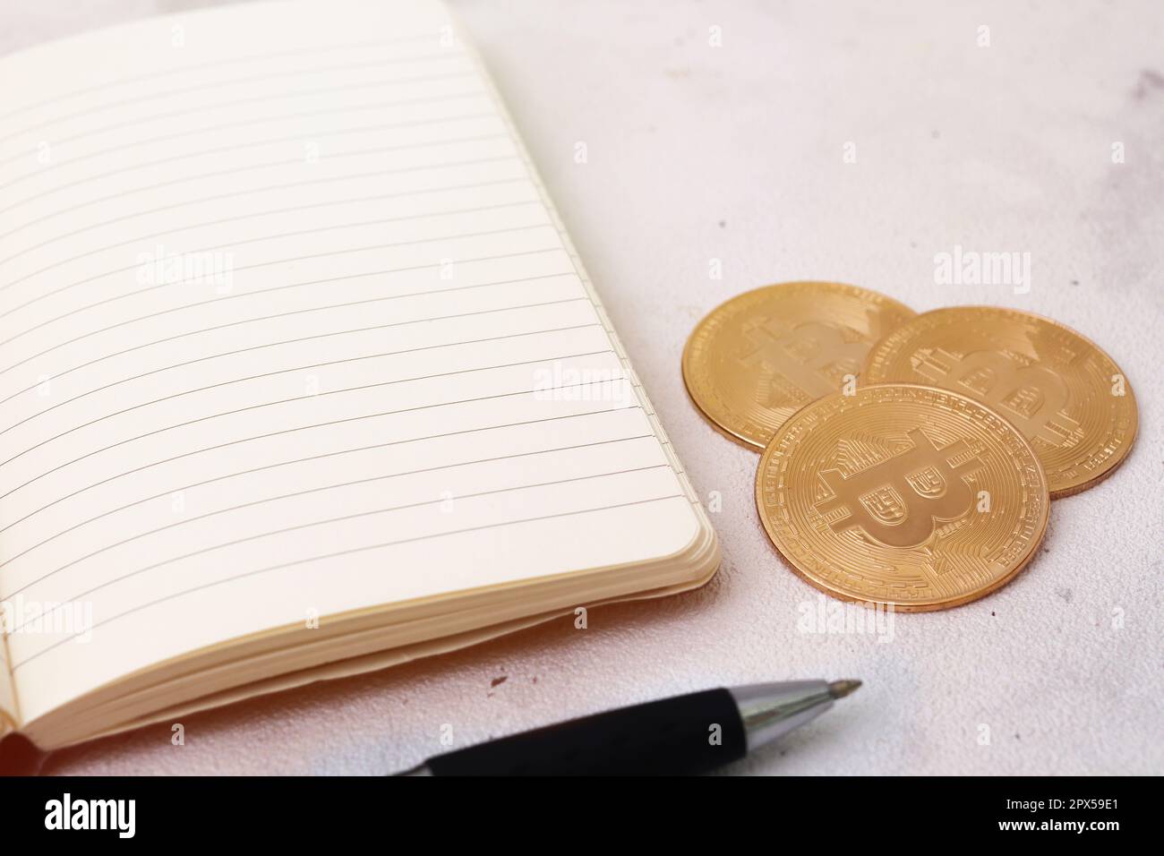 Top view of a pile of bitcoin with empty notebook and ballpoint ...
