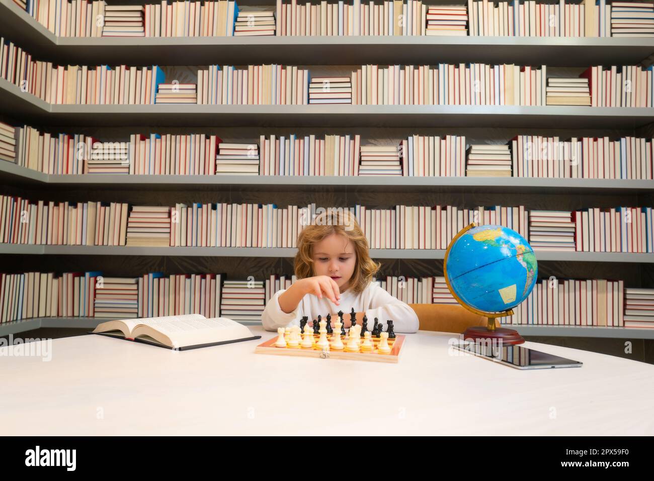 Little child play chess in classroom. Kid playing board game. Thinking ...