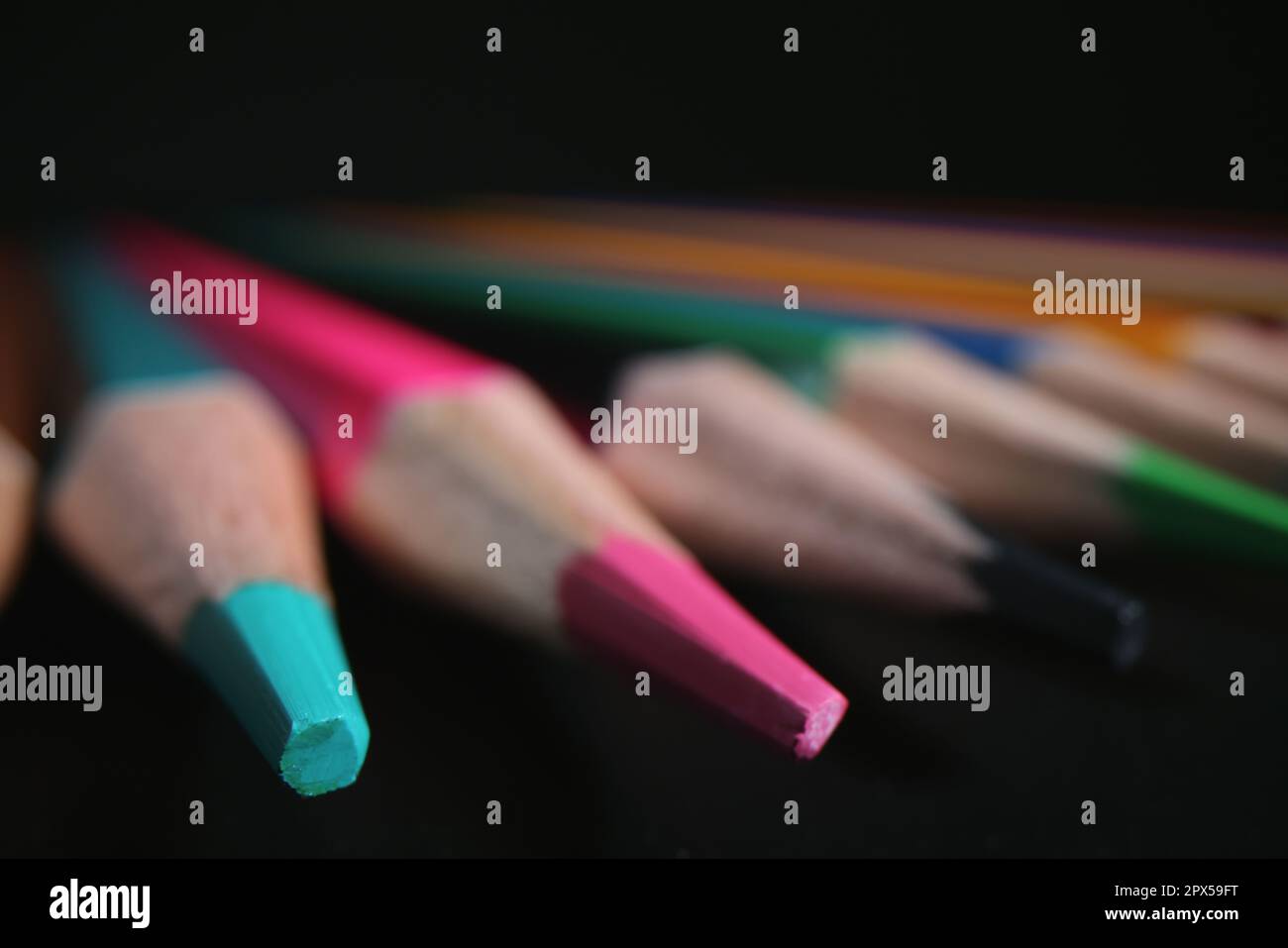 Sharpened multi-colored pencil tips on dark background Stock Photo - Alamy