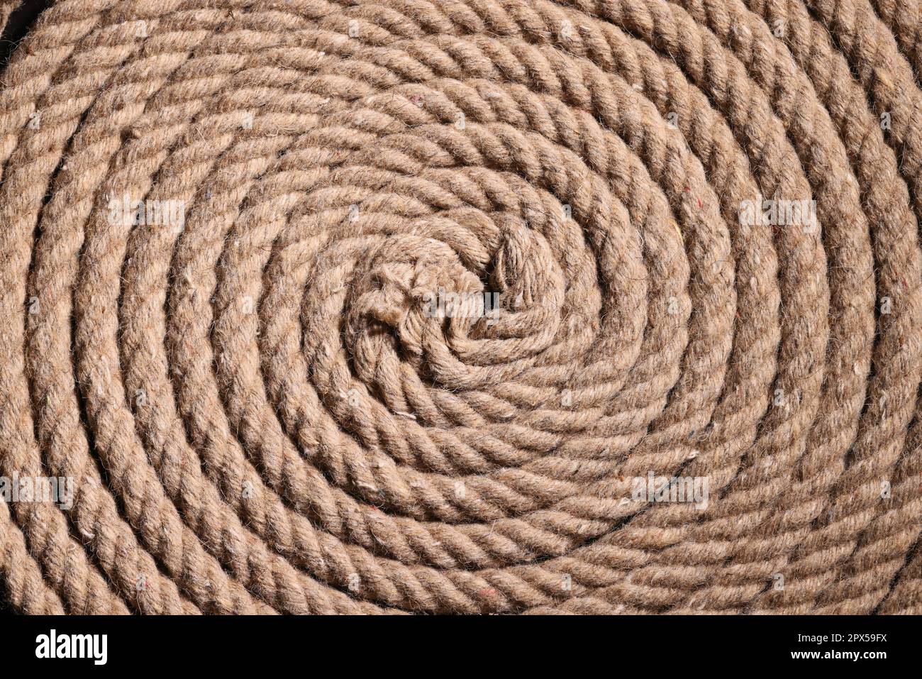 Coil of twisted strong brown rope as background texture Stock Photo - Alamy
