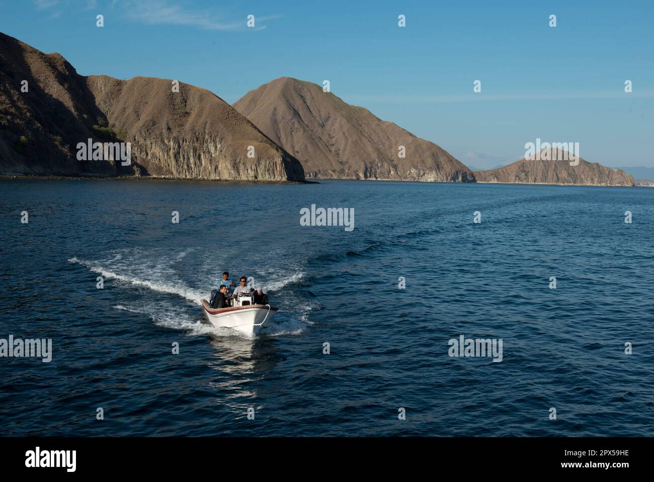 Dive tender boat near coastline and hill, near Padar Island, South ...