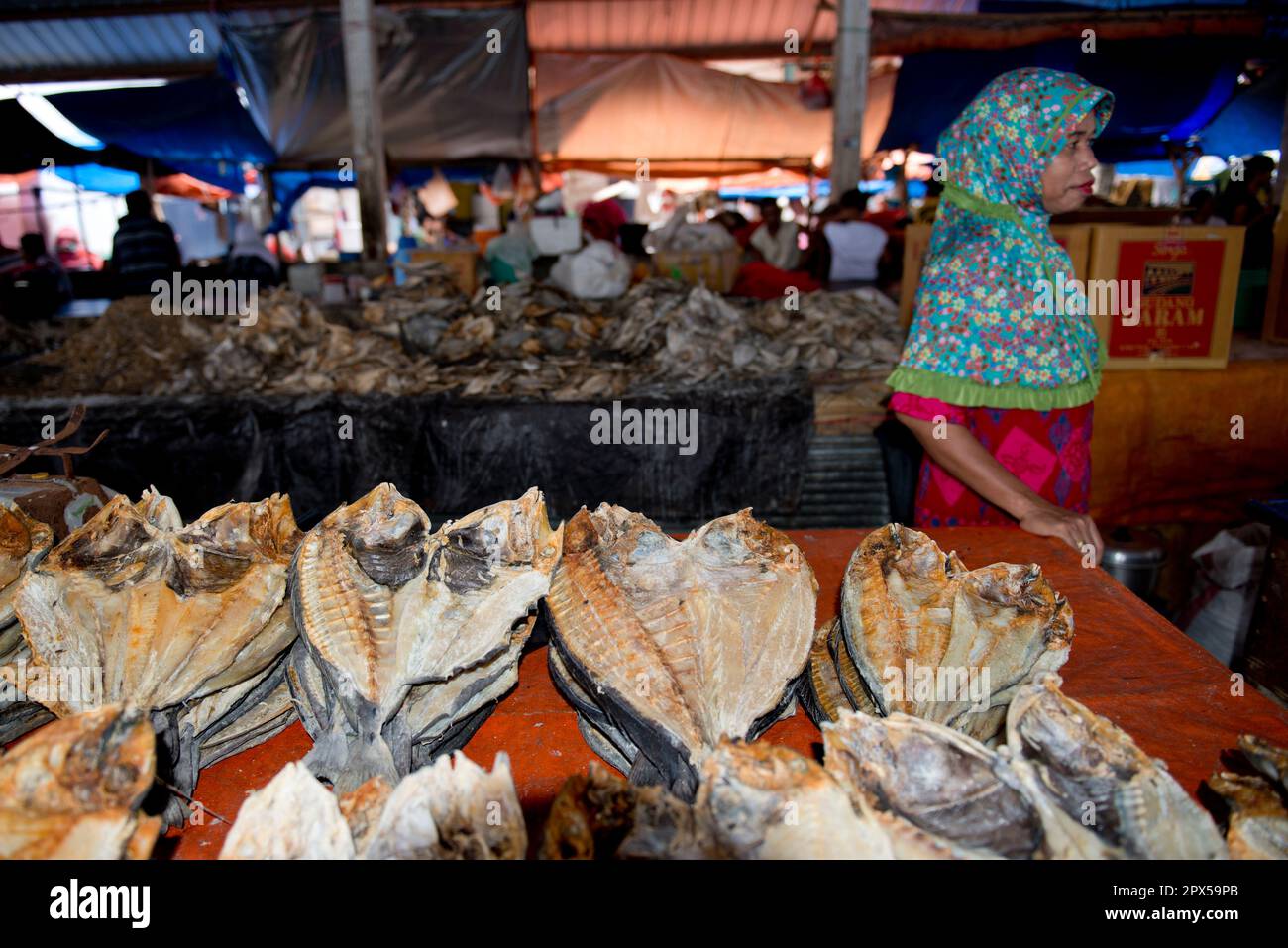 Woman in colorful hijab by dried fish, Fish market, Labuan Bajo, Flores ...