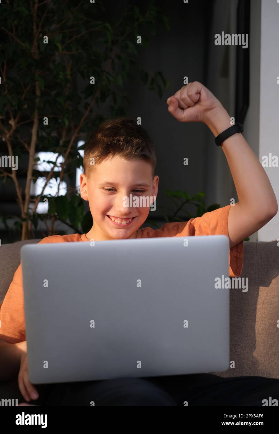 Teen boy study or play game on laptop home interior background. Guy ...