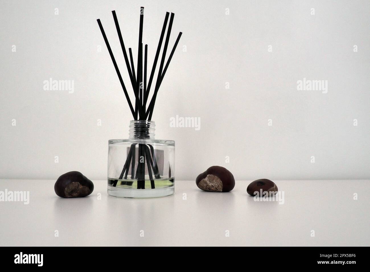 Incense sticks are dipped into a glass cubic vessel with essential oils ...