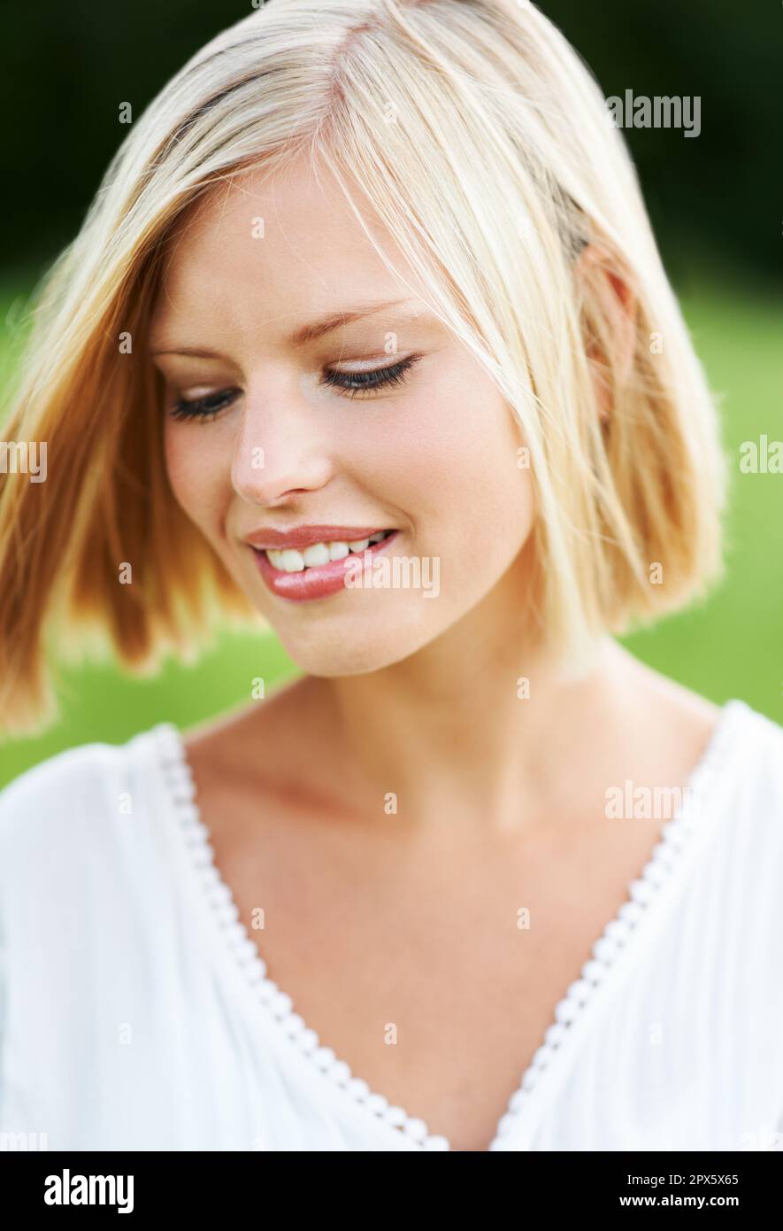 Sweet and naturally lovely. Gorgeous young woman looking downwards ...