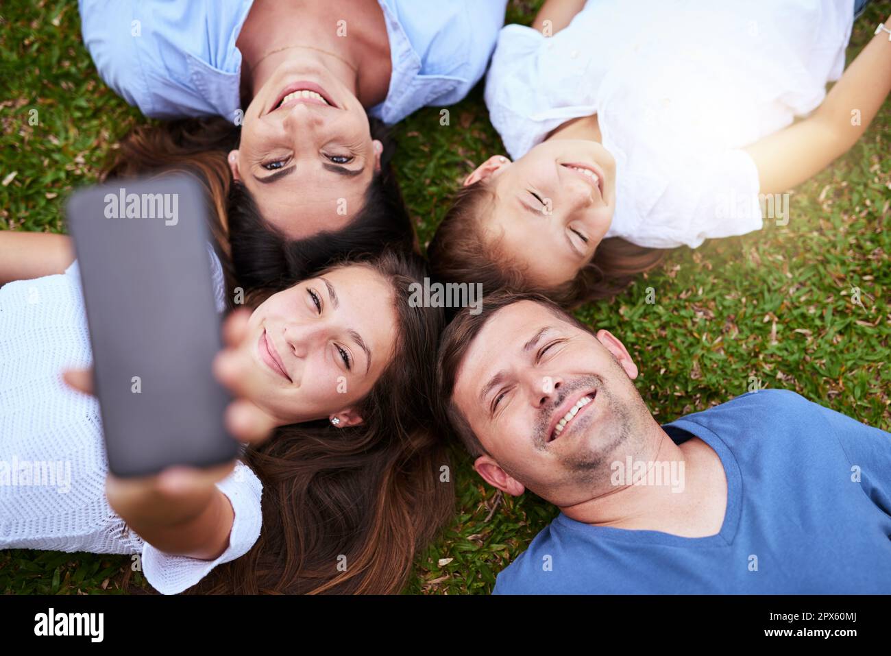 Its a weekend with the family. Portrait of a cheerful family lying on the ground while taking a ...