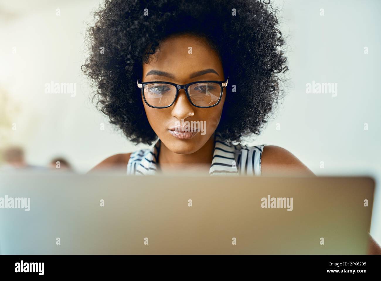 Working hard at those designs. a young female designer working in a ...
