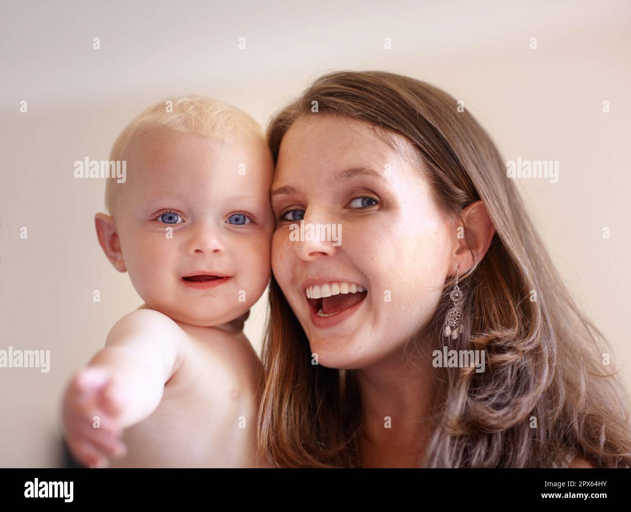 Smile for the camera. Young beautiful mother holding her cute baby Stock Photo - Alamy
