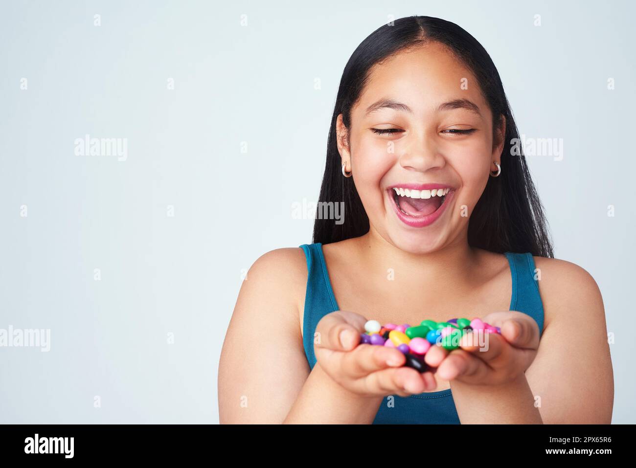 Life just got a little bit sweeter. Studio shot of a cute young girl ...