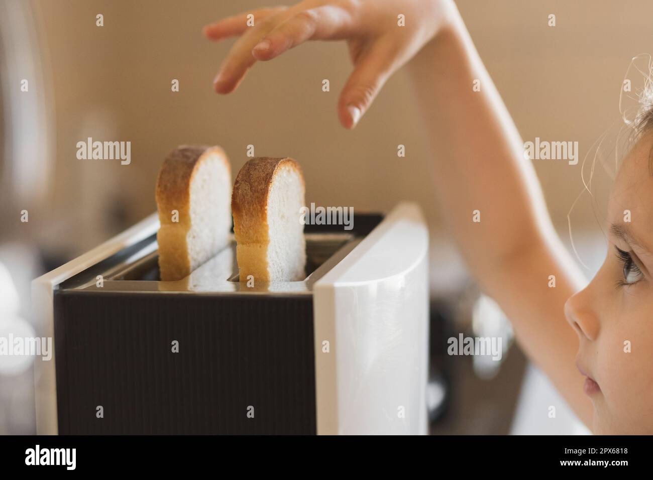 Close-up of a 5-7 year old girl who is preparing breakfast from toast ...