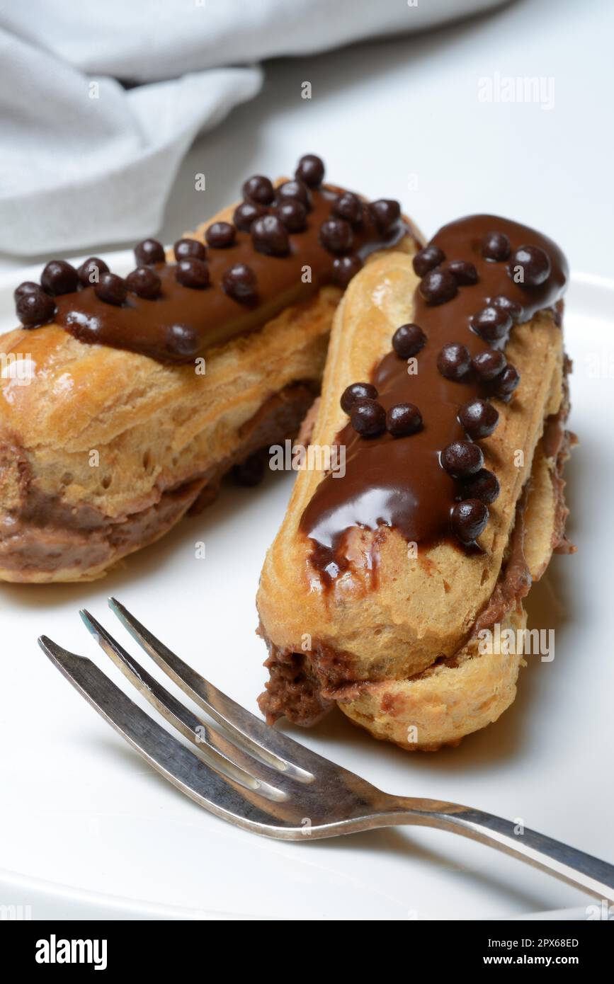 Two chocolate eclairs on a plate, eclair Stock Photo - Alamy