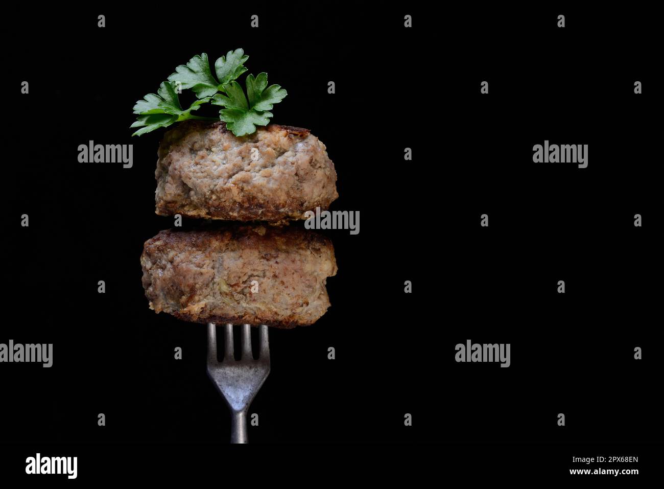 Two homemade meatballs on fork, minced meat Stock Photo - Alamy