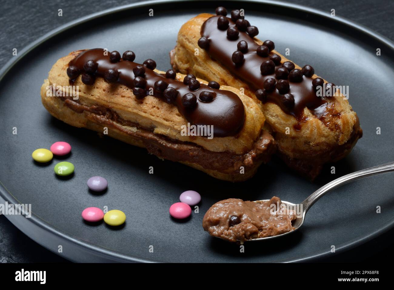 Two chocolate eclairs on a plate, eclair Stock Photo - Alamy