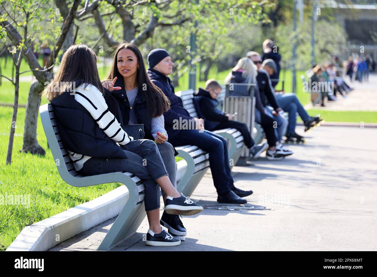 Two girls talking on bench hi-res stock photography and images - Alamy