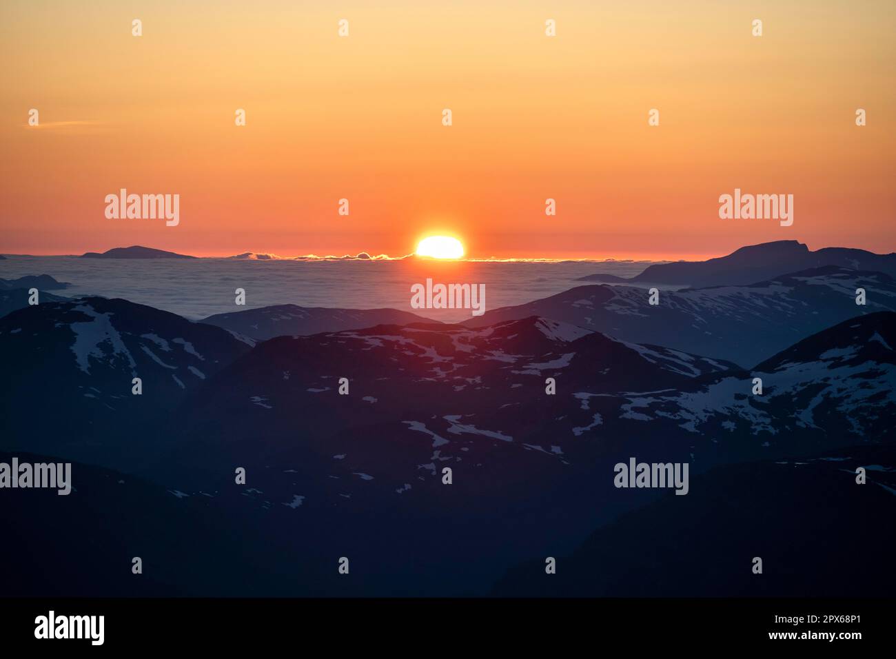 Sunset behind the mountains, mountain panorama with remnants of snow ...