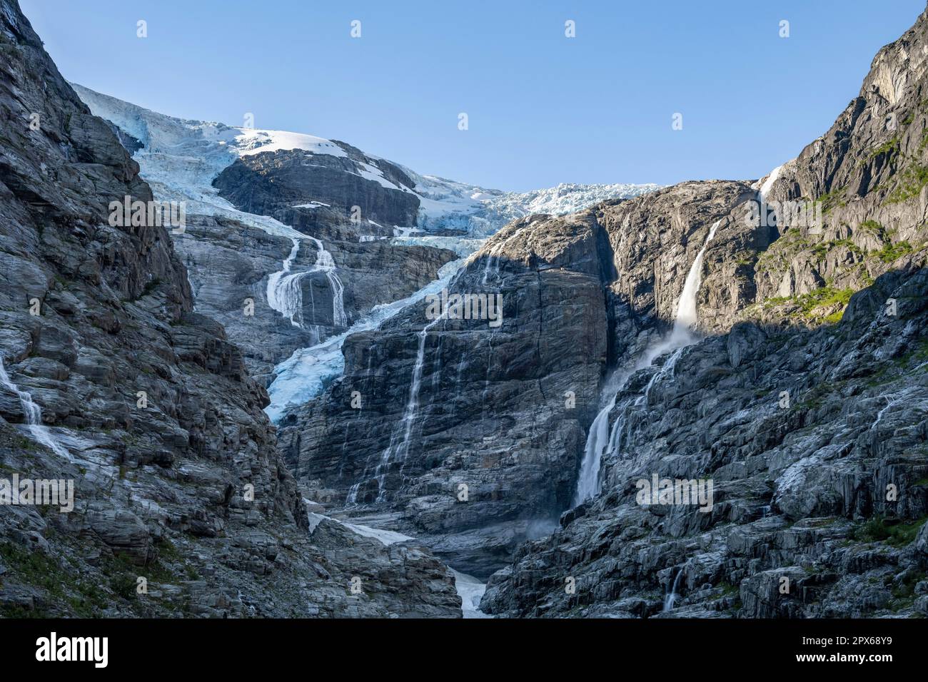 Waterfalls at the glacier tongue Kjenndalsbreen, glacier and mountain ...