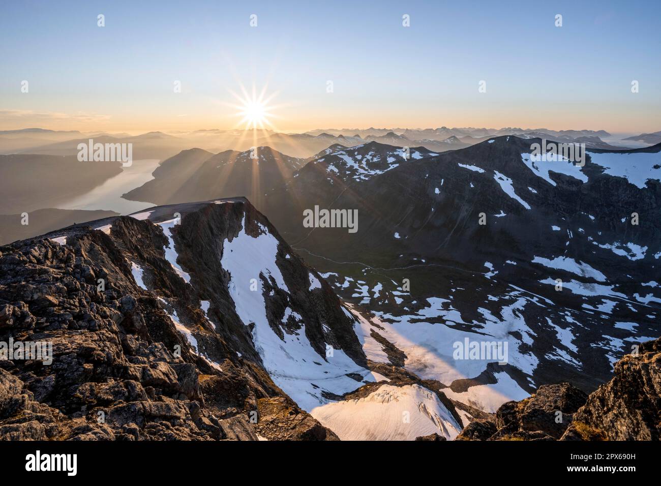 View of mountains and fjord Faleidfjorden, sun star at sunset, summit ...