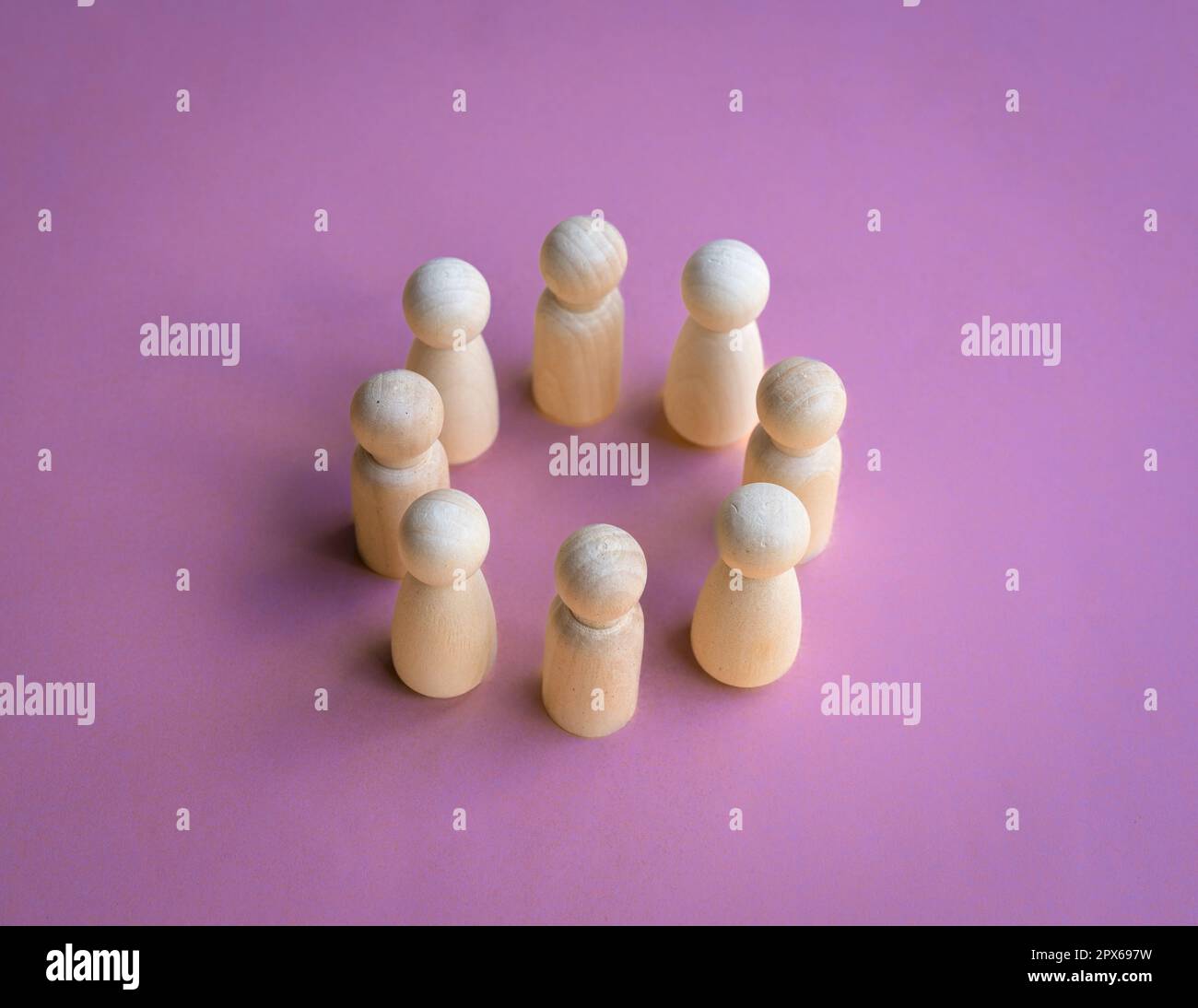 Wooden dolls standing in a circle facing each other. Team decision or ...