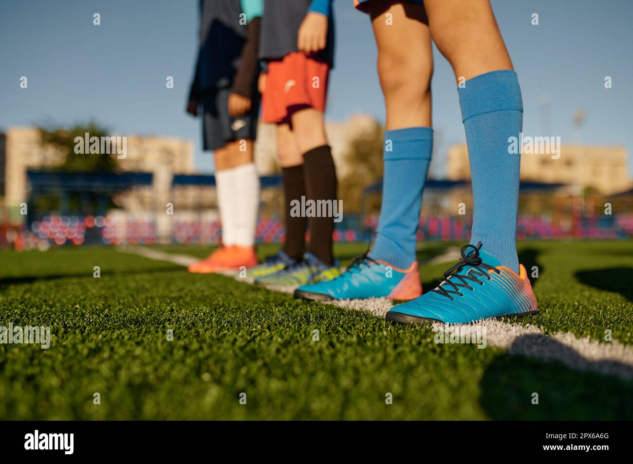 Closeup leg of teenage football player on white line across green ...