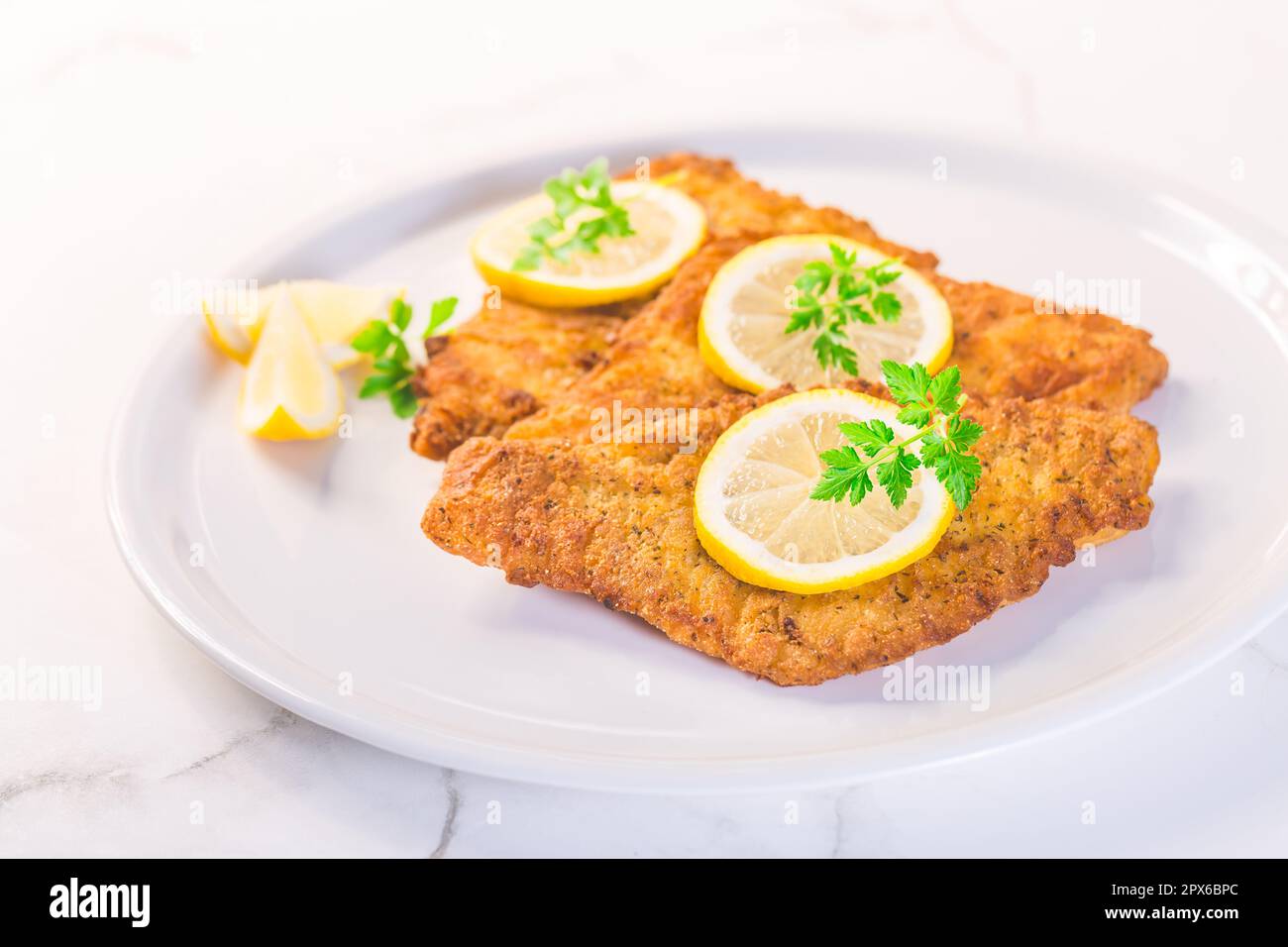 Breaded fish, baked and served with lemon. Common dab, edible flatfisch ...