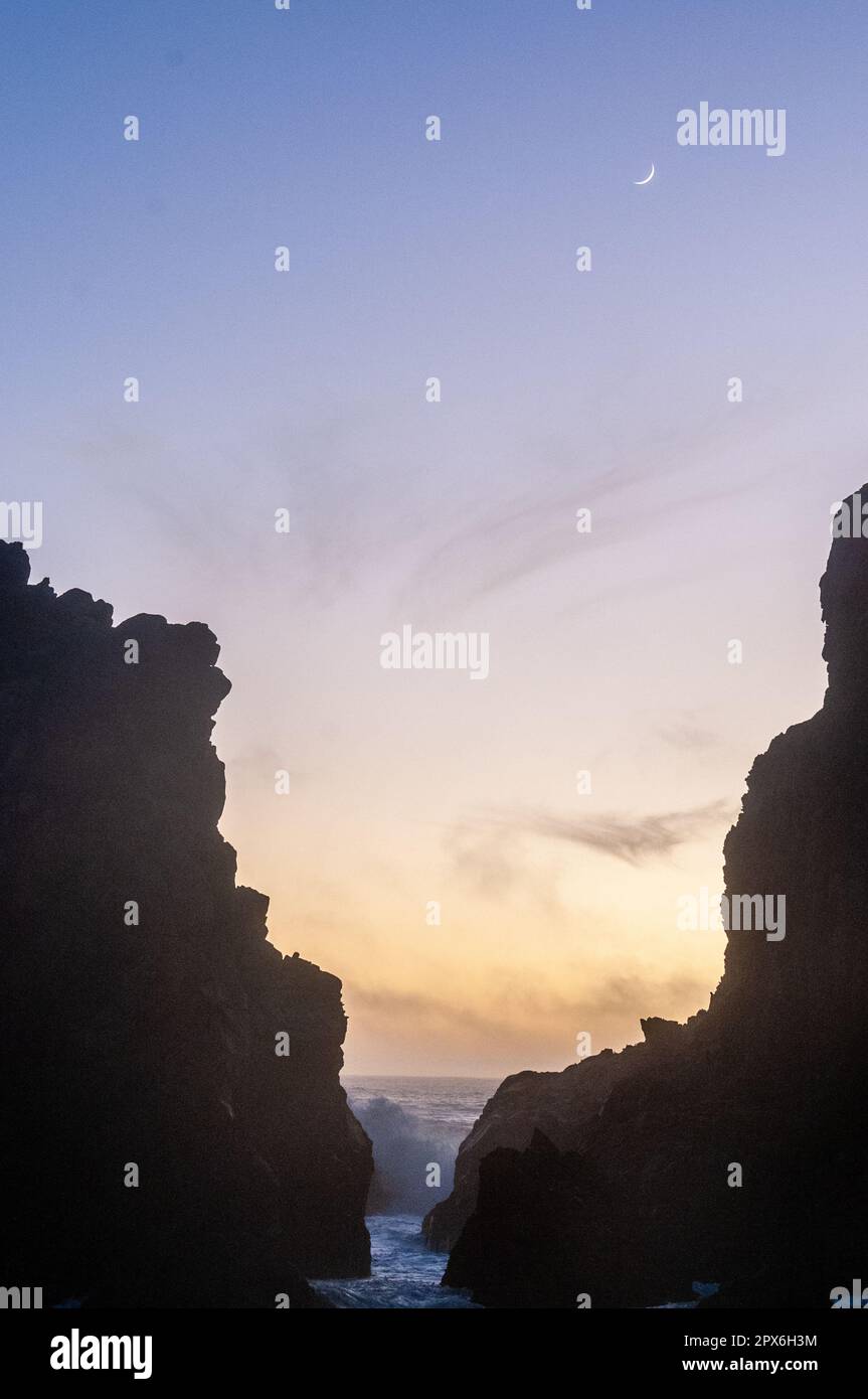Incoming waves from the pacific ocean are breaking through the rocks at ...