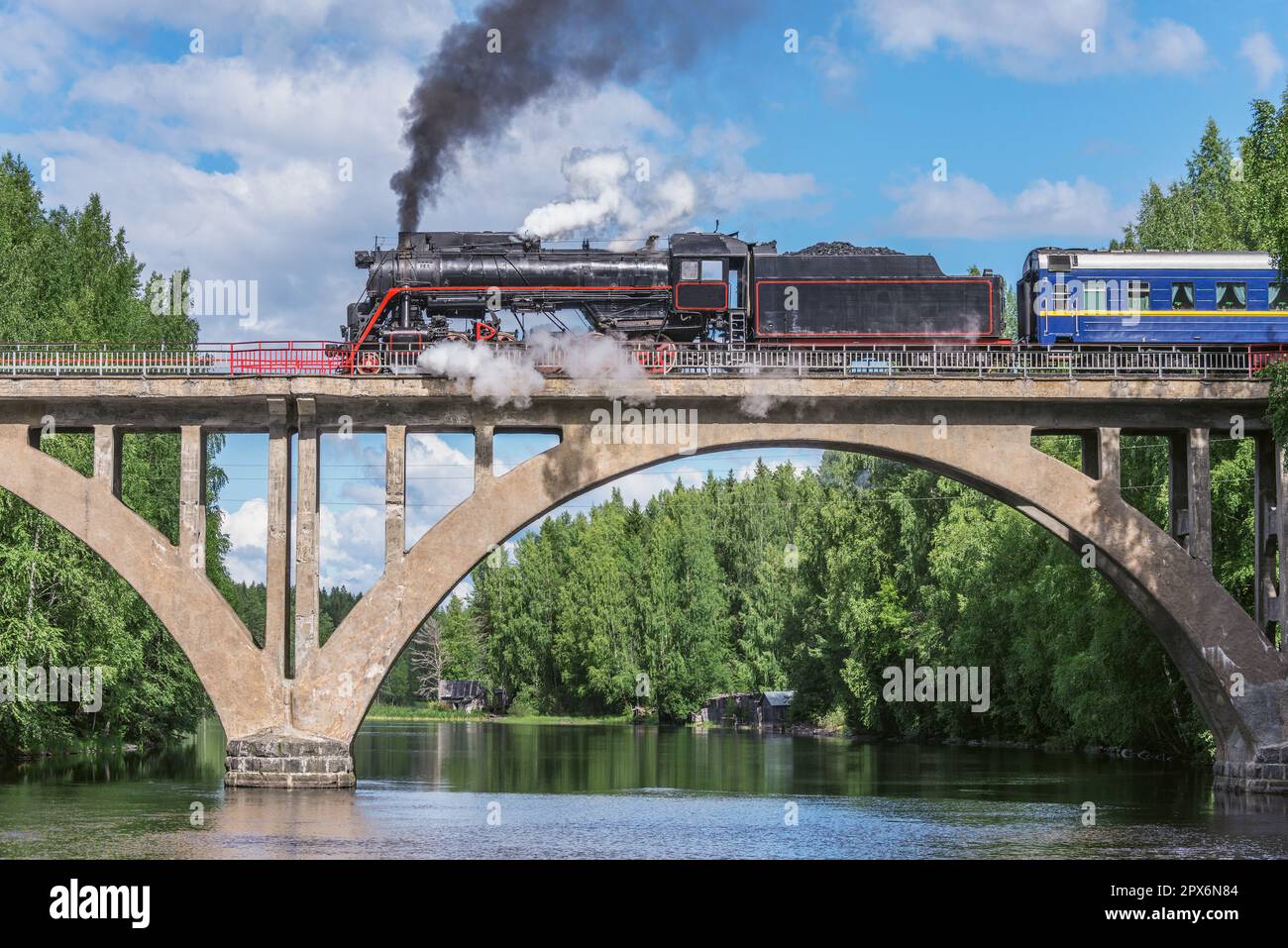 Retro steam train moves above the river Stock Photo - Alamy