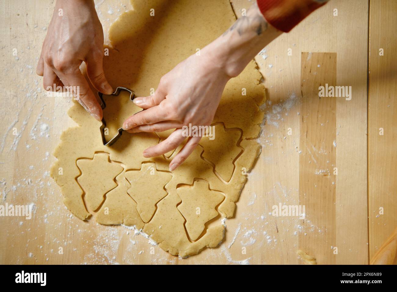 Top view of female hand cutting out biscuits from dough with cookie ...
