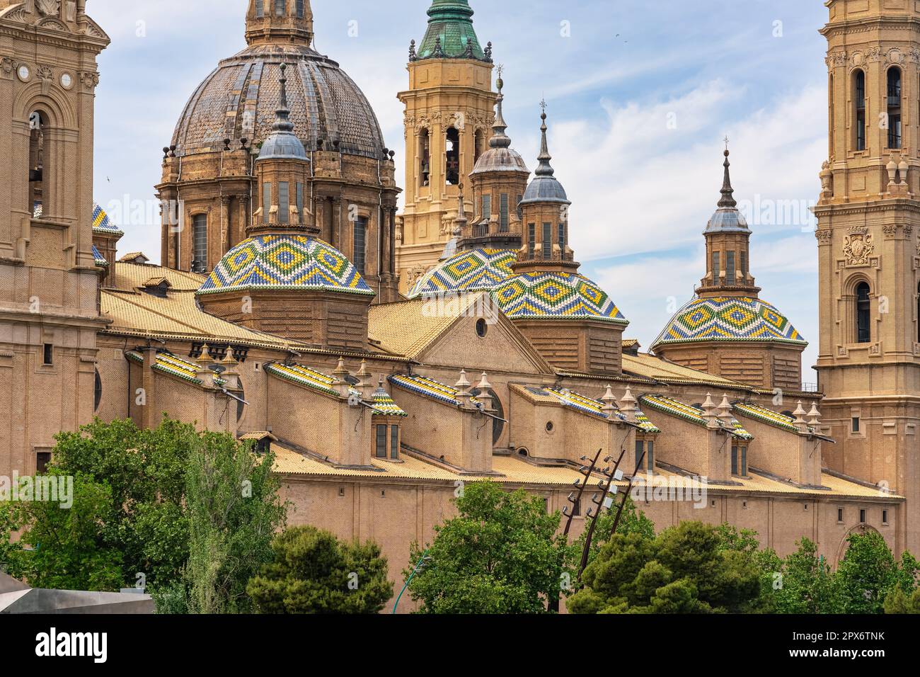 Domes with brightly colored tiles and Mudejar style towers of the ...