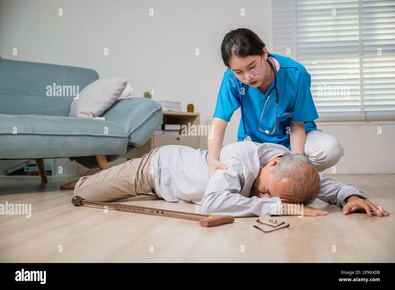Asian older senior man falling down on lying floor and woman nurse came ...