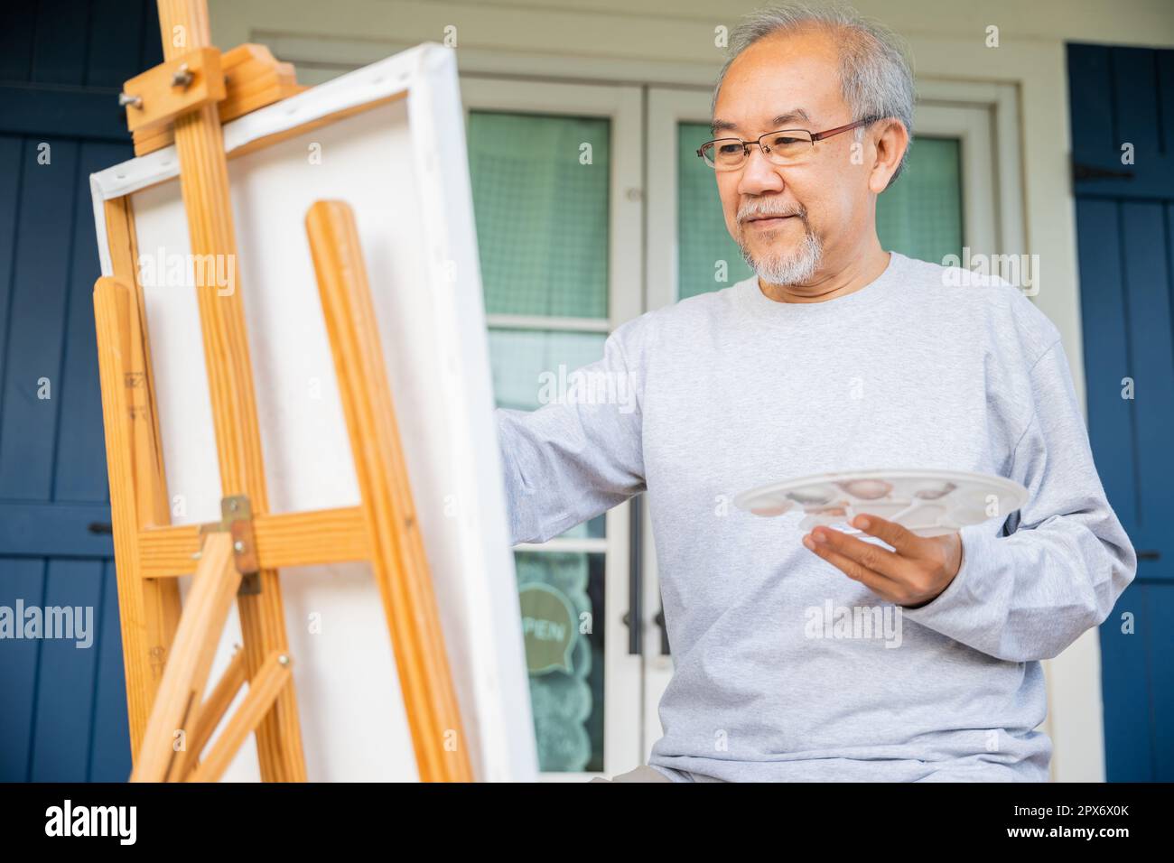 Lifestyle elderly people smile paint at his easel outside home, Asian ...