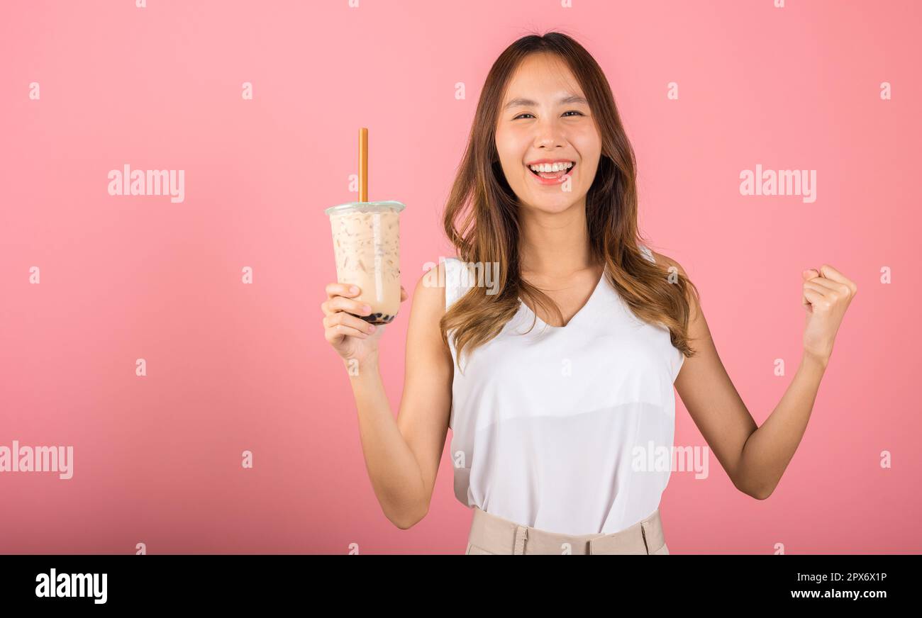 Excited Asian beautiful woman holding drinking brown sugar flavored ...