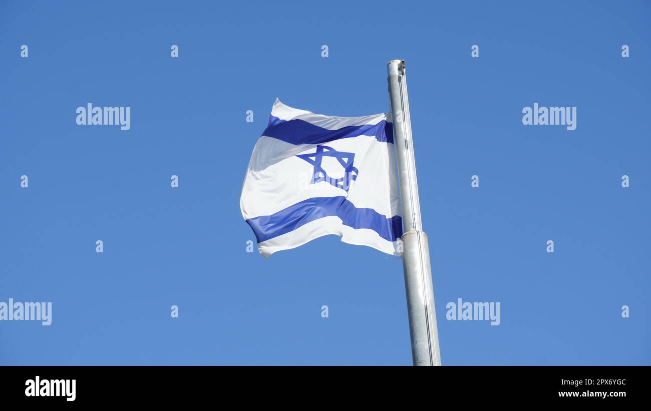 Israeli flag weaving in the wind against bright skies Stock Photo - Alamy