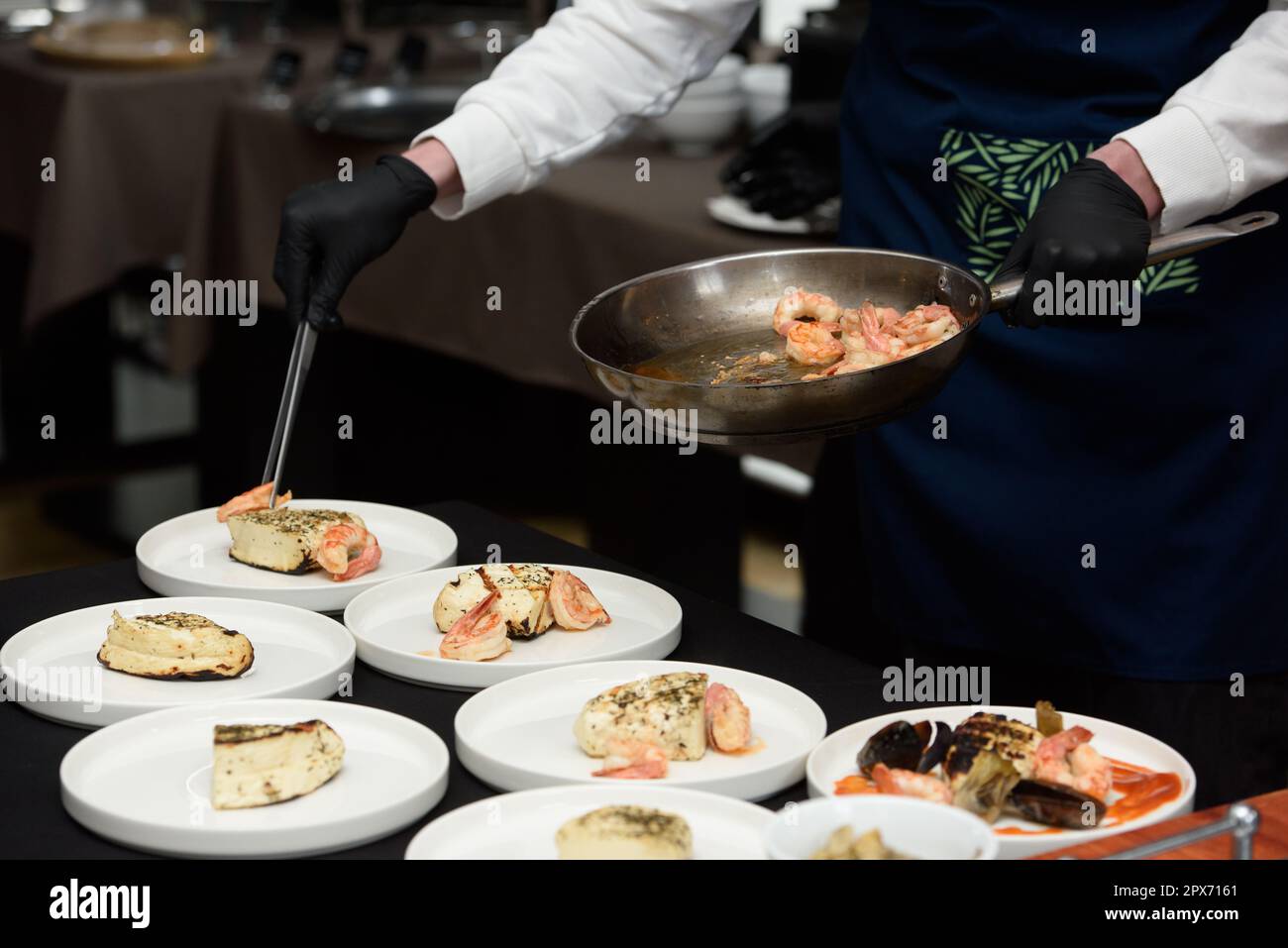 chef in the restaurant prepares saganaki, traditional Greek cheese ...