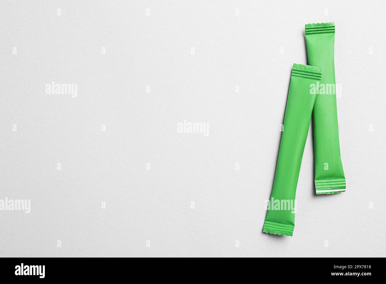 Green sticks of sugar on light grey background, flat lay. Space for ...