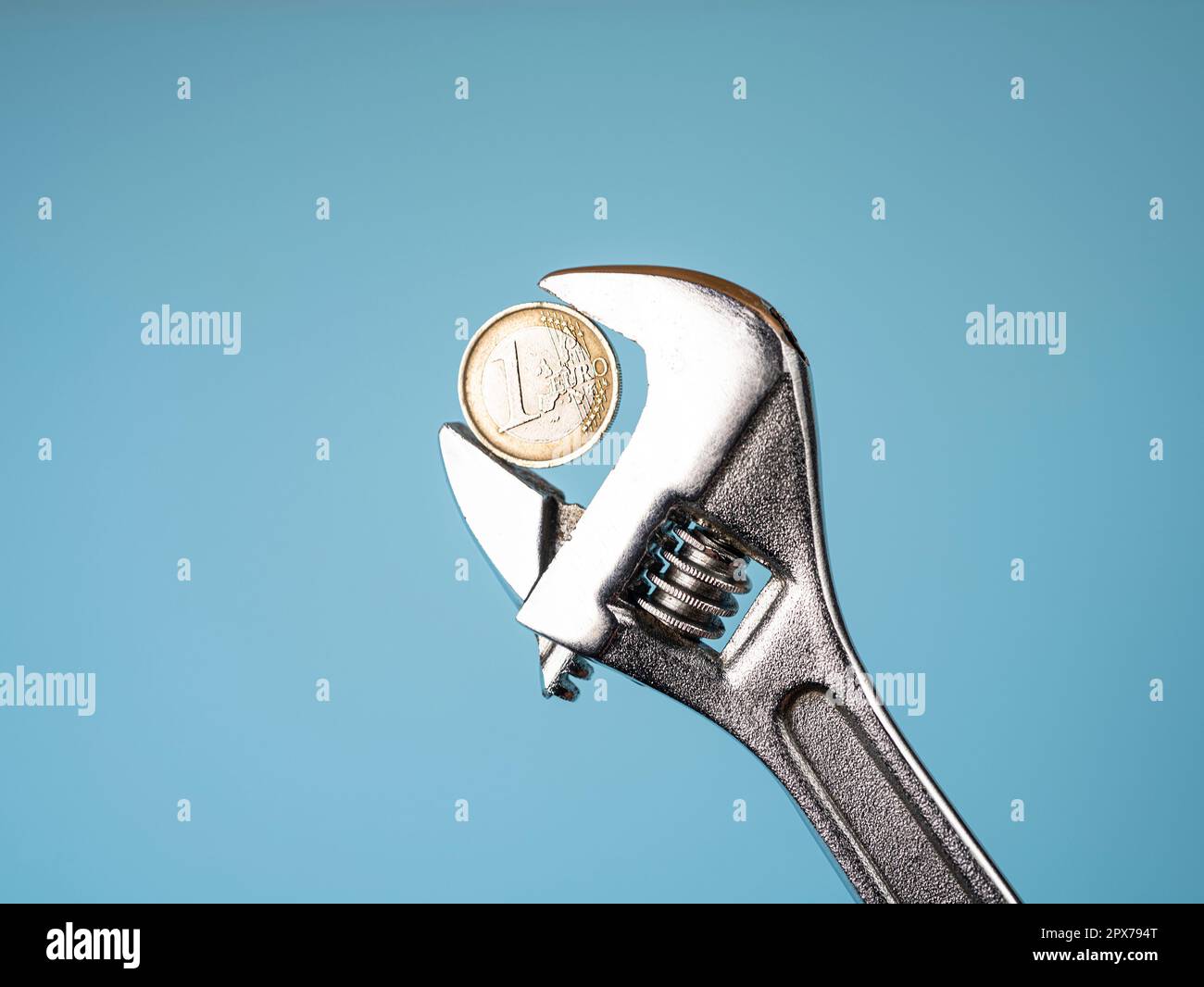 the one euro coin tightened with an adjustable wrench Stock Photo - Alamy