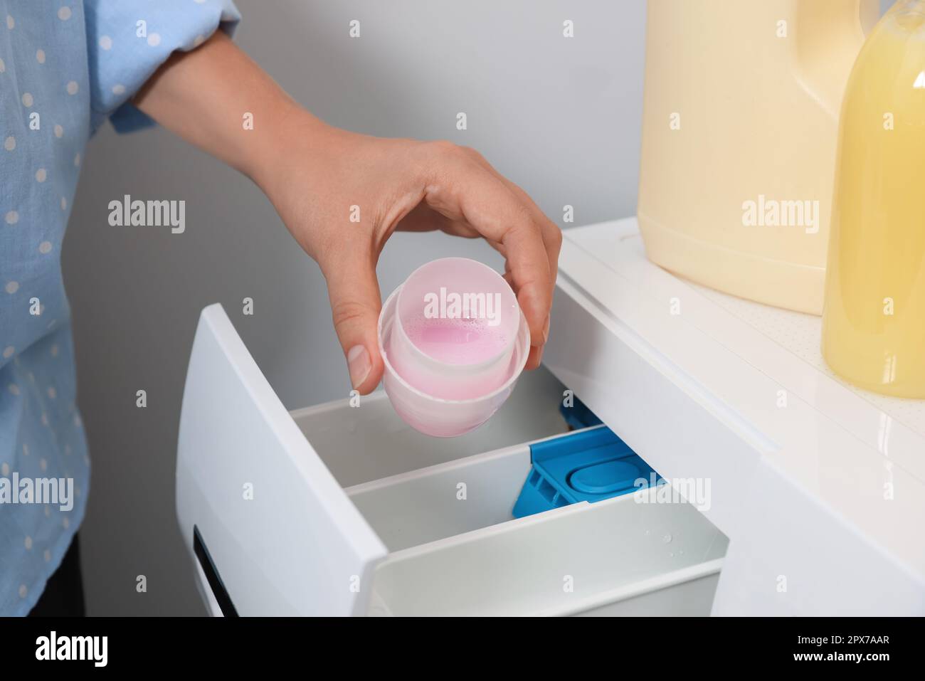 Woman pouring laundry detergent into drawer of washing machine, closeup ...