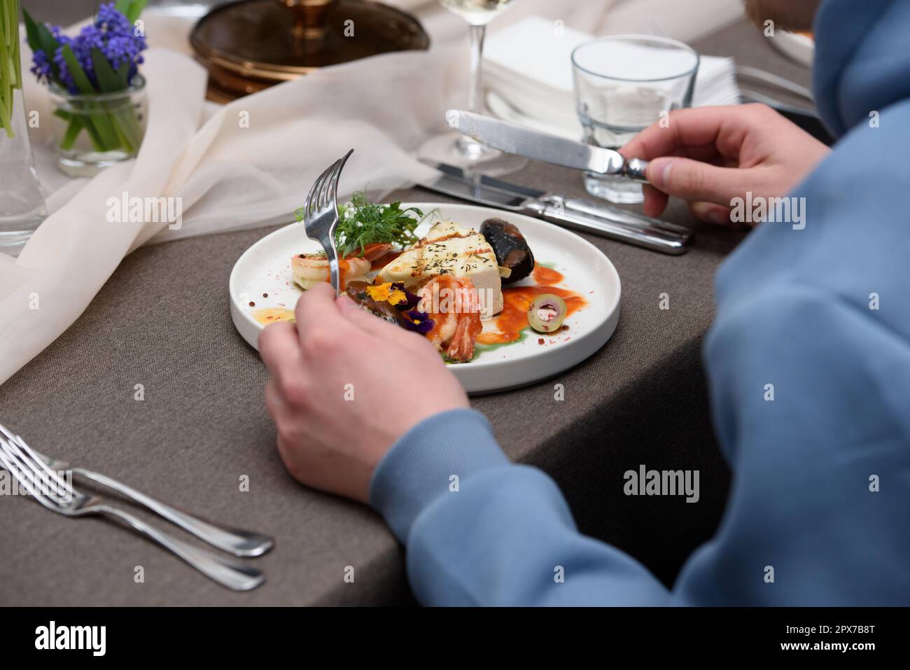 man going to eat saganaki, traditional Greek cheese snack served on a ...