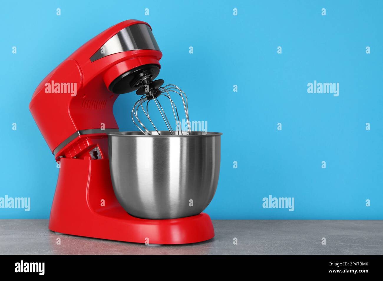 Modern red stand mixer on gray marble table against turquoise ...