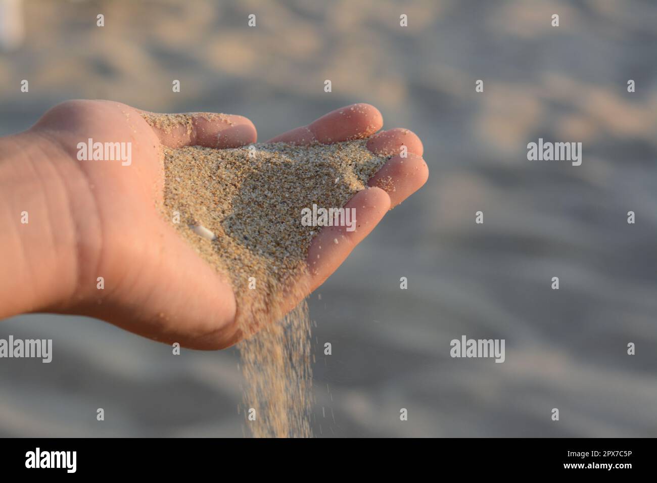 Girl pouring sand from hand outdoors, closeup. Fleeting time concept ...