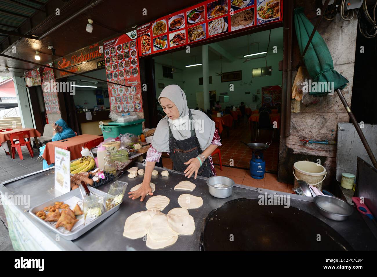 A Muslim Thai woman preparing Roti in a small restaurant near the ...