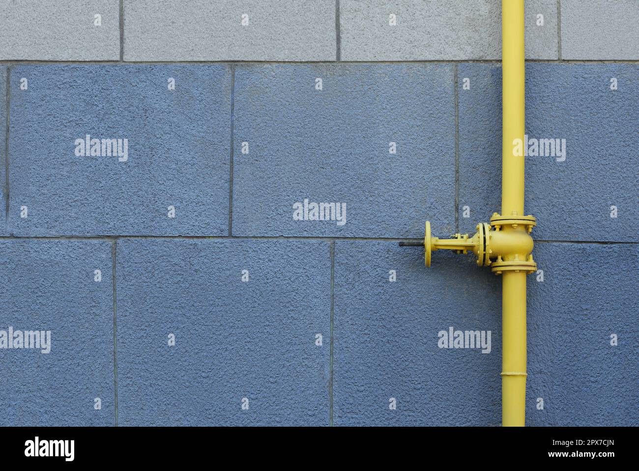 Yellow gas pipe on grey wall outdoors Stock Photo - Alamy