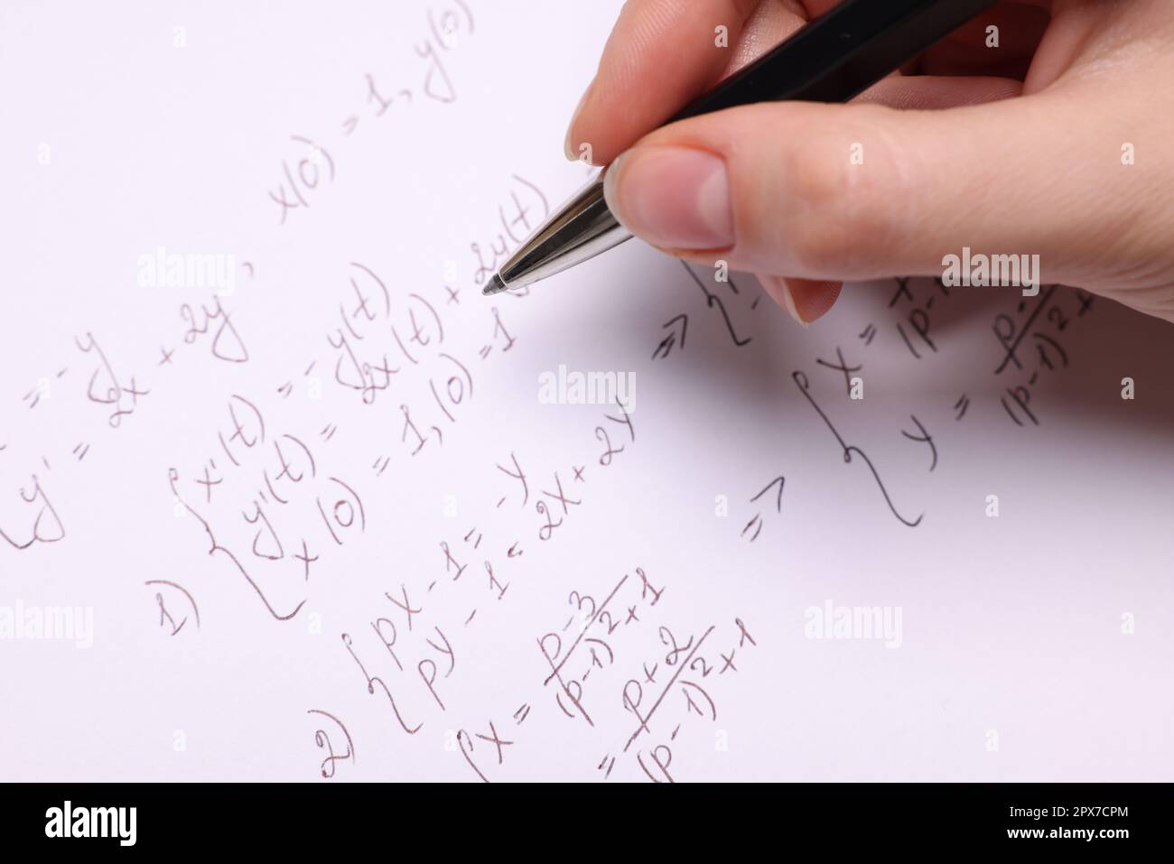 Student writing different mathematical formulas on paper, closeup Stock ...