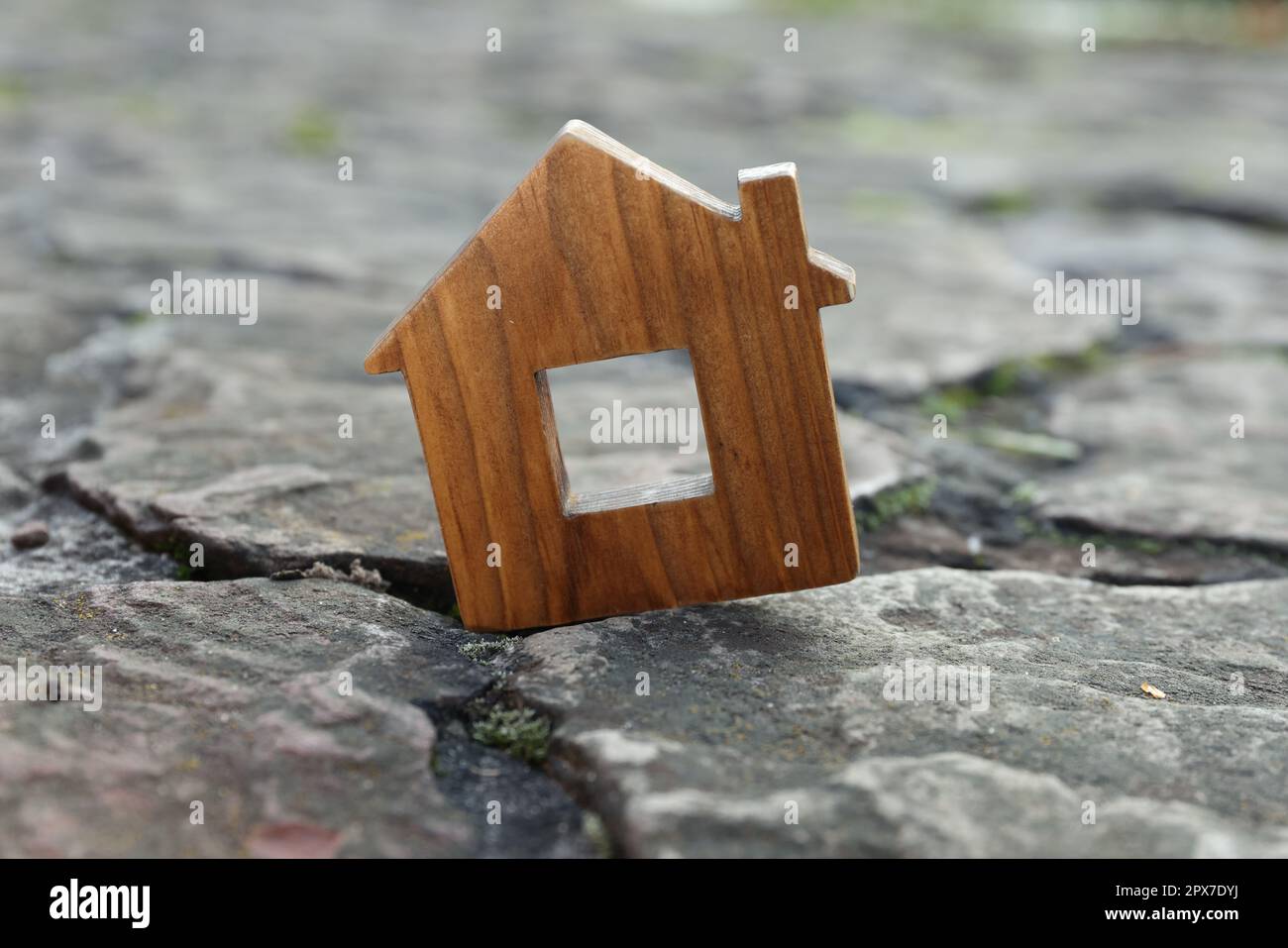 Wooden house model between cracks on stone road. Earthquake disaster ...
