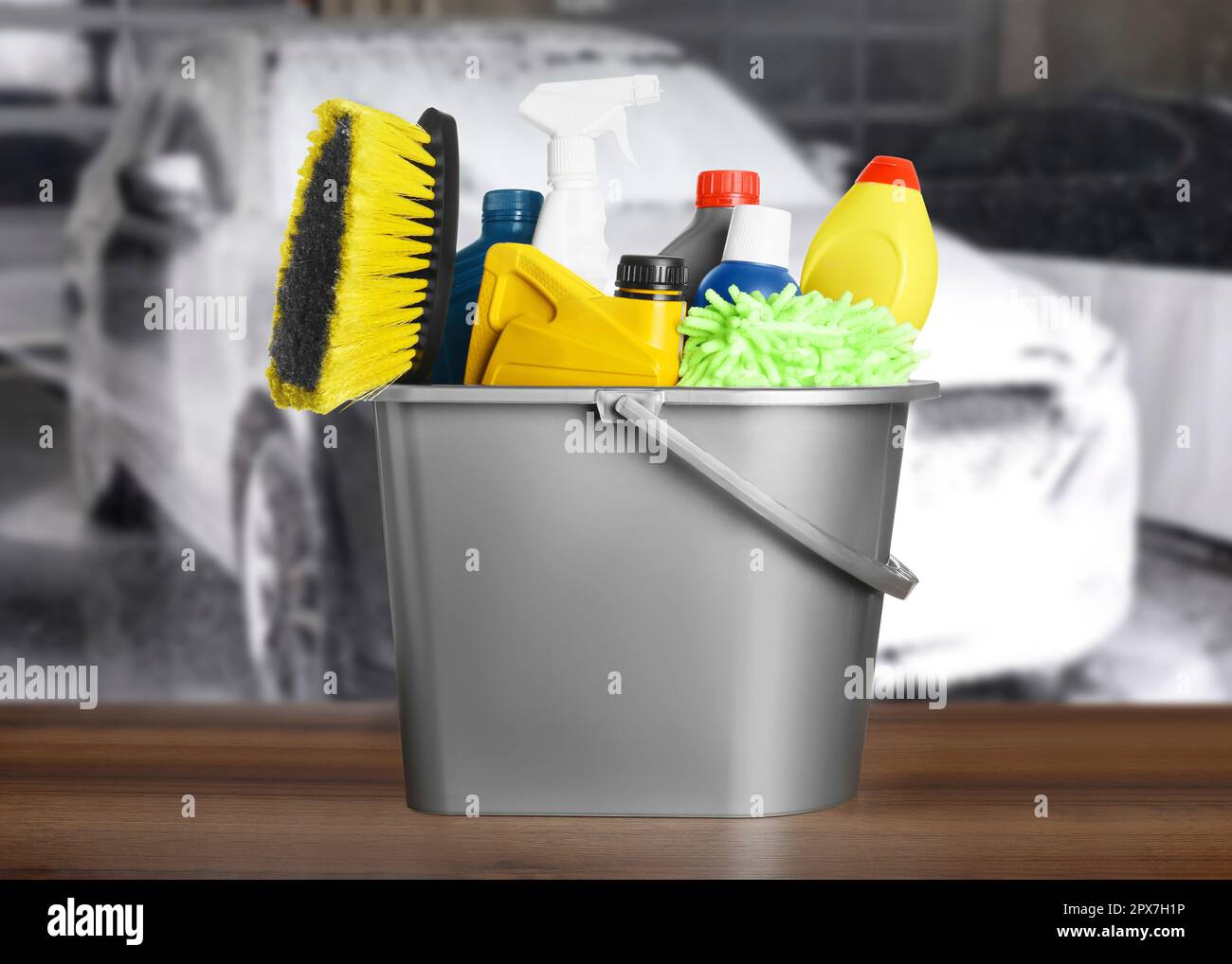 Bucket with cleaning supplies on wooden surface at car wash Stock Photo ...