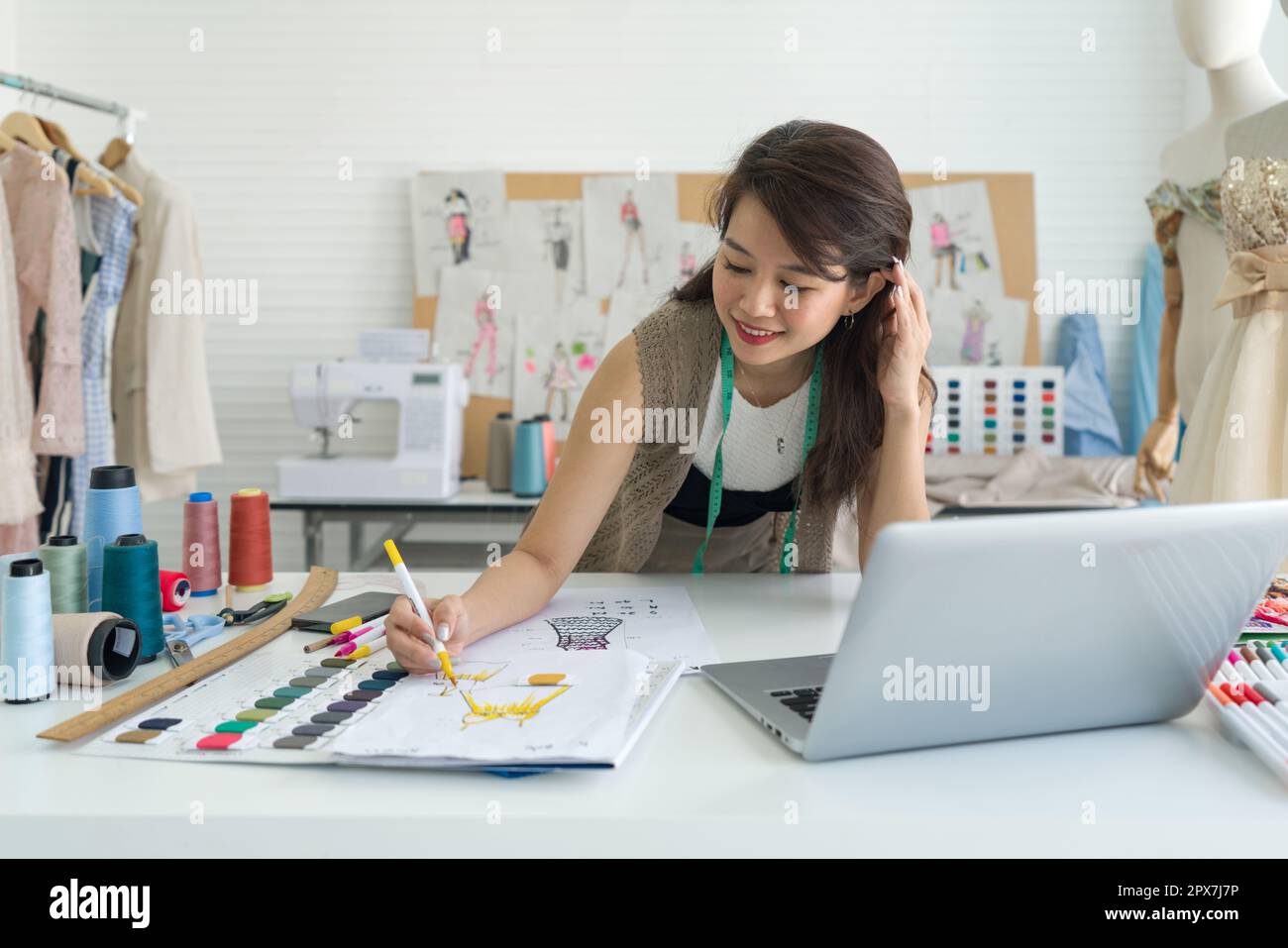 Young fashion designer use magic pen painting on pattern for cloth ...