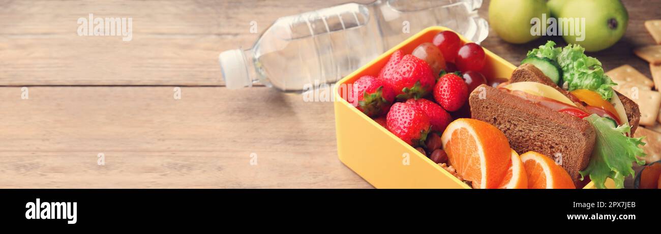 School meal. Lunch box with healthy food on wooden table, space for ...
