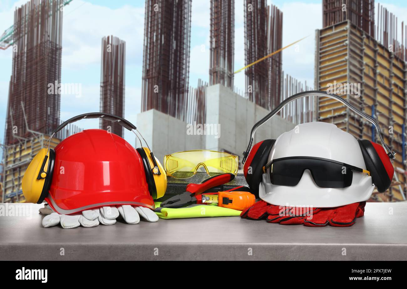 Safety equipment and tools on grey stone surface and blurred view of ...