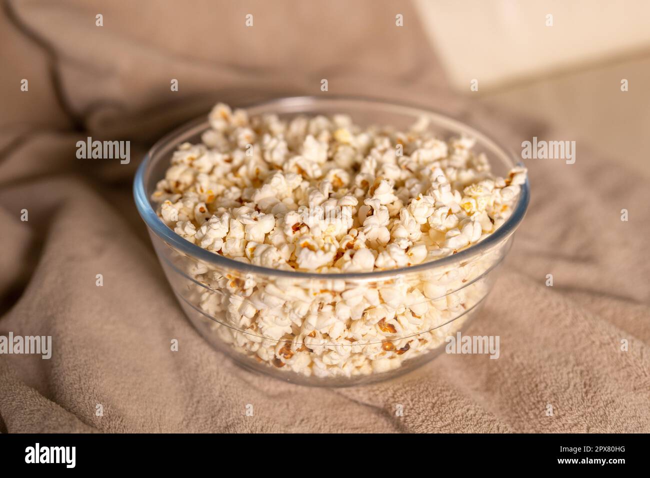 Bowl of popcorn for watching a film on a beige couch. Snacks and ...