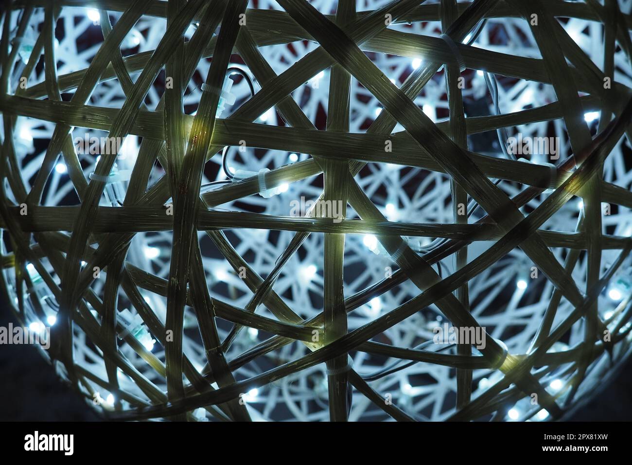 Light fixture with garlands inside. A ball wrapped in rods or stripes ...