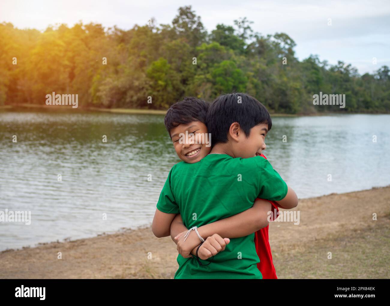 Brothers hug each other by the reservoir in the evening Stock Photo - Alamy